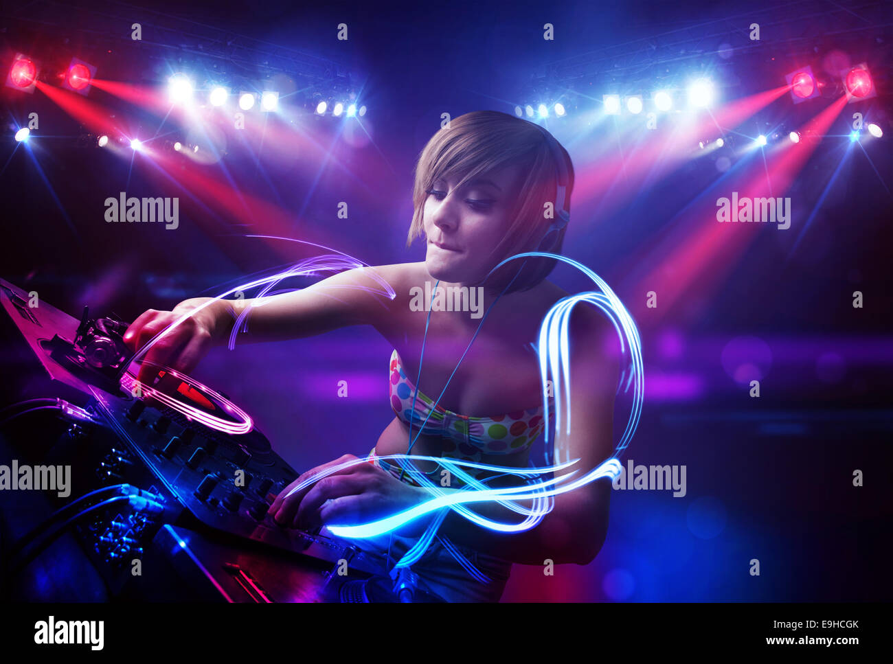 Disc jockey girl playing music with light beam effects on stage Stock ...