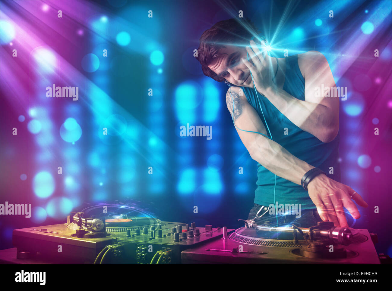 Dj mixing music in a club with blue and purple lights Stock Photo - Alamy