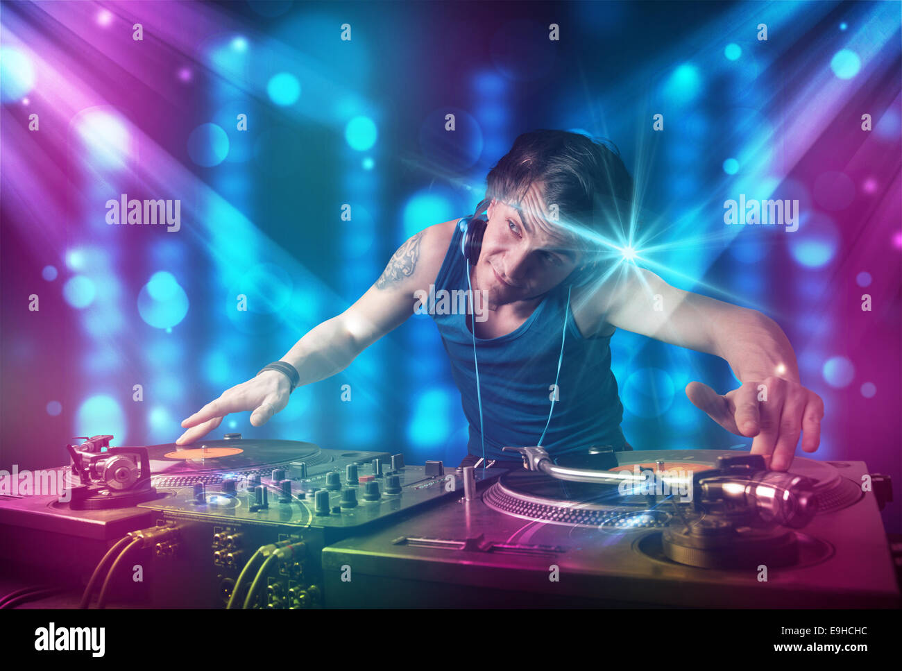 Dj mixing music in a club with blue and purple lights Stock Photo - Alamy