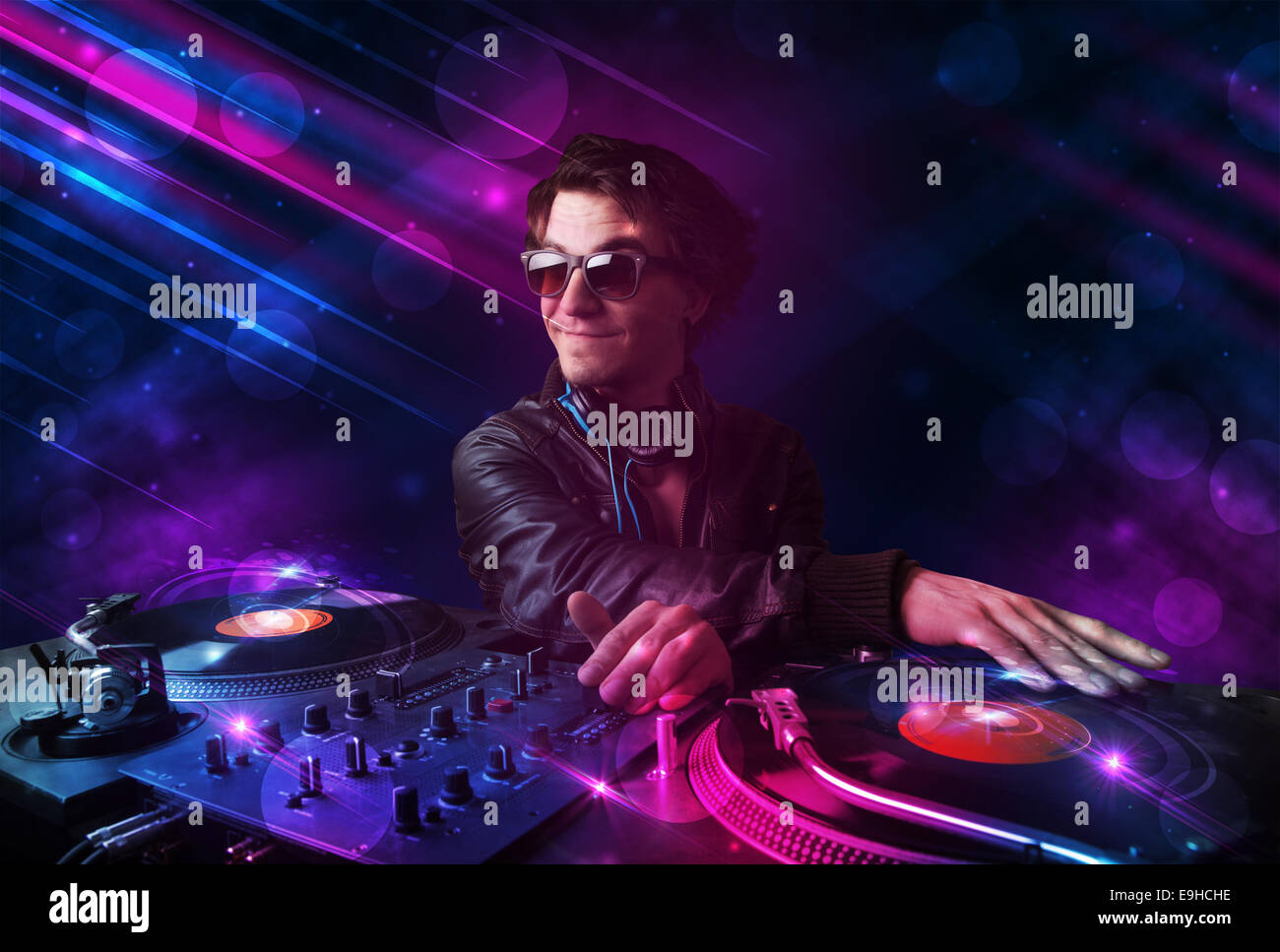 Young DJ playing on turntables with color light effects Stock Photo - Alamy