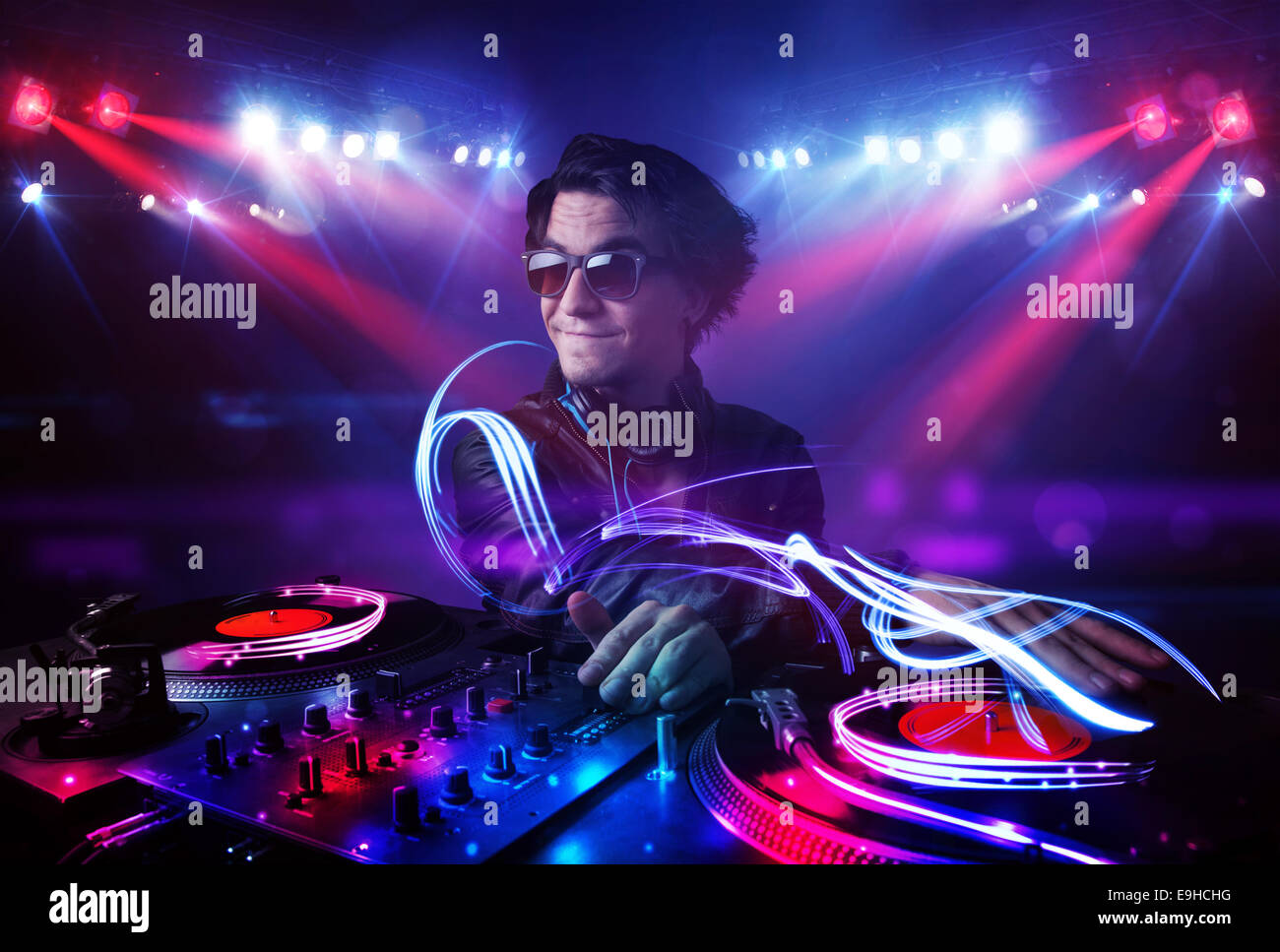 Disc jockey playing music with light beam effects on stage Stock Photo ...