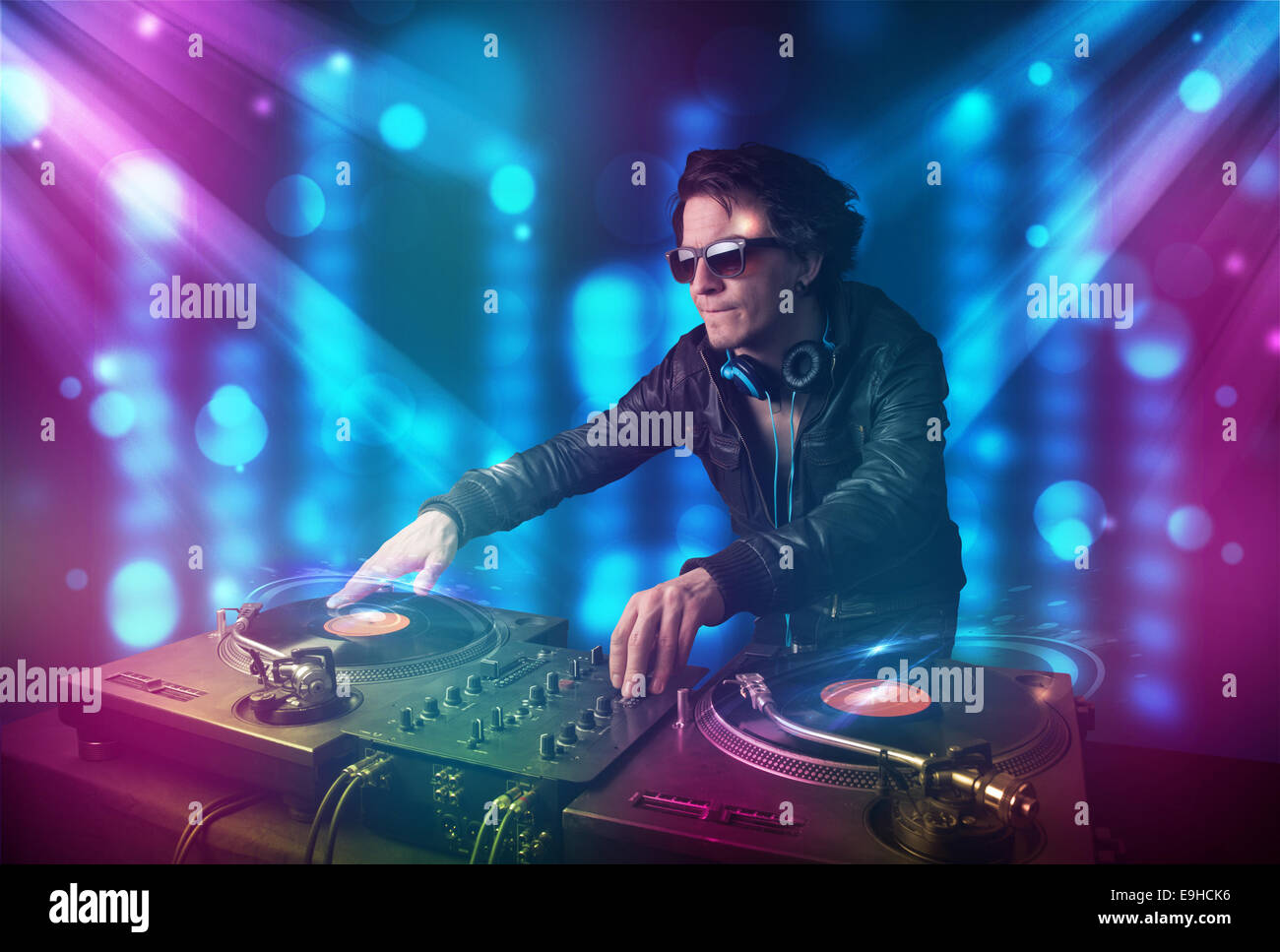 Dj mixing music in a club with blue and purple lights Stock Photo - Alamy
