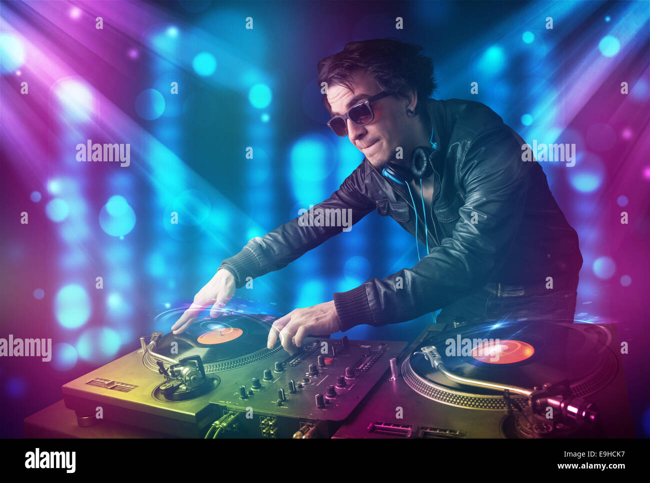 Dj mixing music in a club with blue and purple lights Stock Photo - Alamy