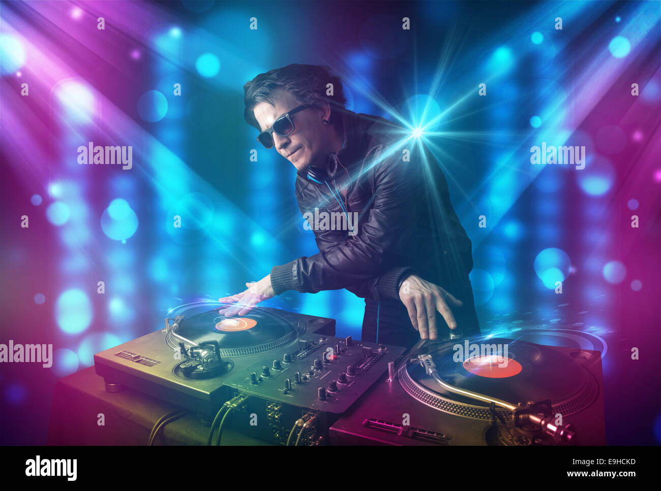 Dj mixing music in a club with blue and purple lights Stock Photo - Alamy