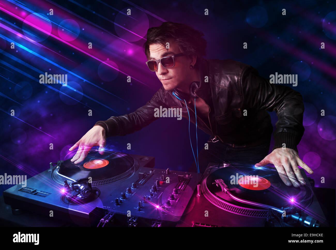 Young DJ playing on turntables with color light effects Stock Photo - Alamy