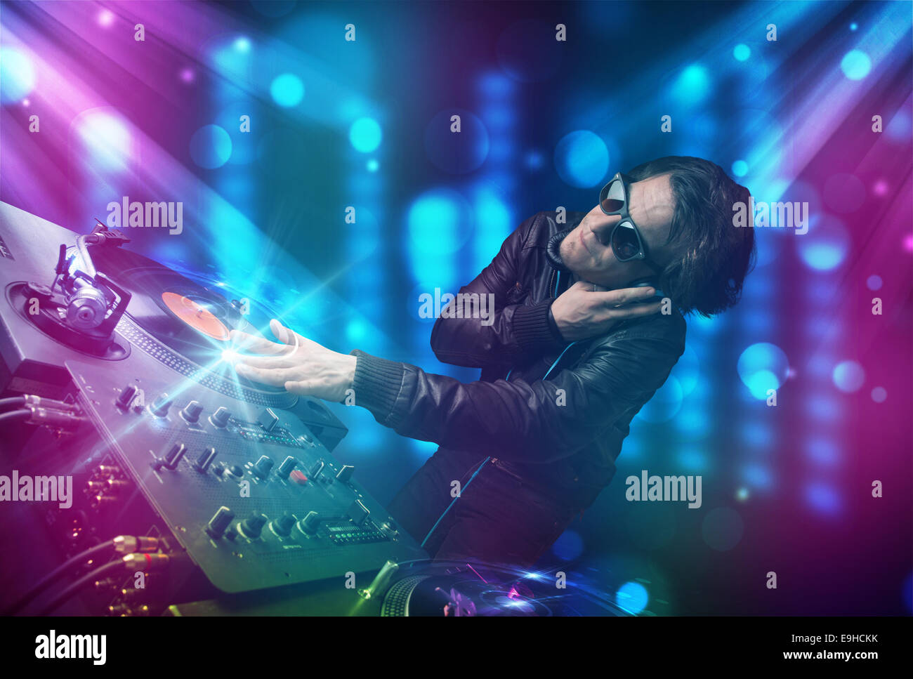 Dj mixing music in a club with blue and purple lights Stock Photo - Alamy