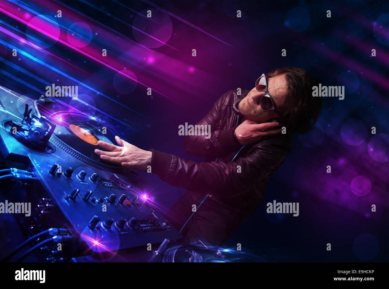 Young DJ playing on turntables with color light effects Stock Photo - Alamy