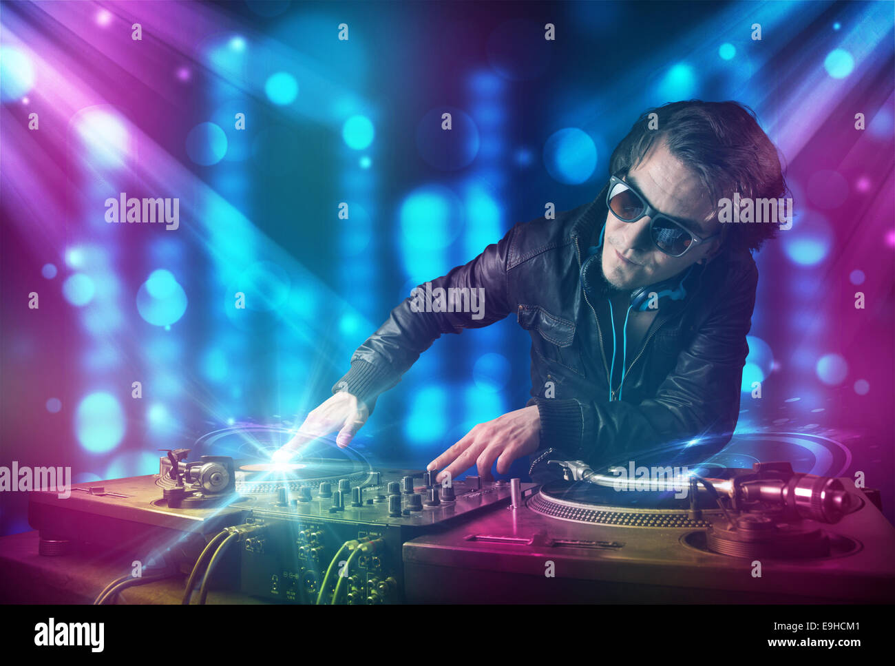 Dj mixing music in a club with blue and purple lights Stock Photo - Alamy