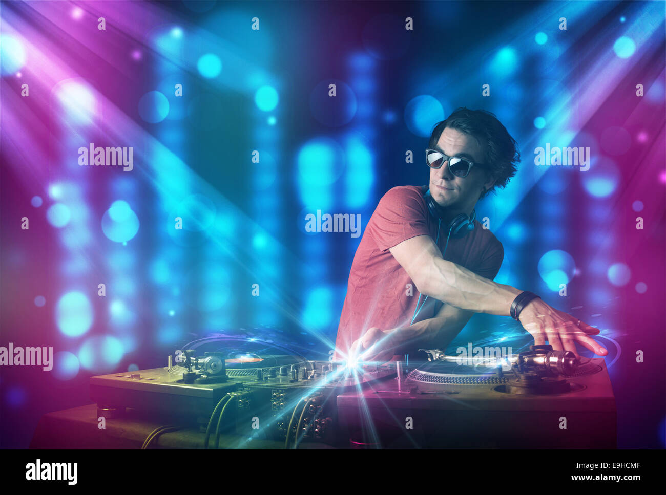 Dj mixing music in a club with blue and purple lights Stock Photo - Alamy