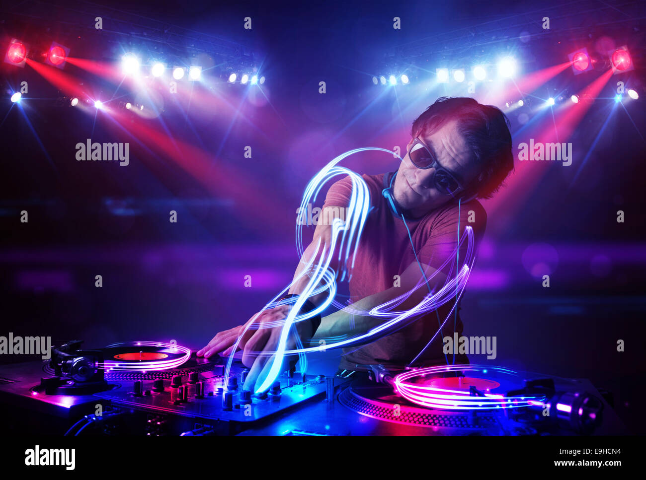 Disc jockey playing music with light beam effects on stage Stock Photo ...