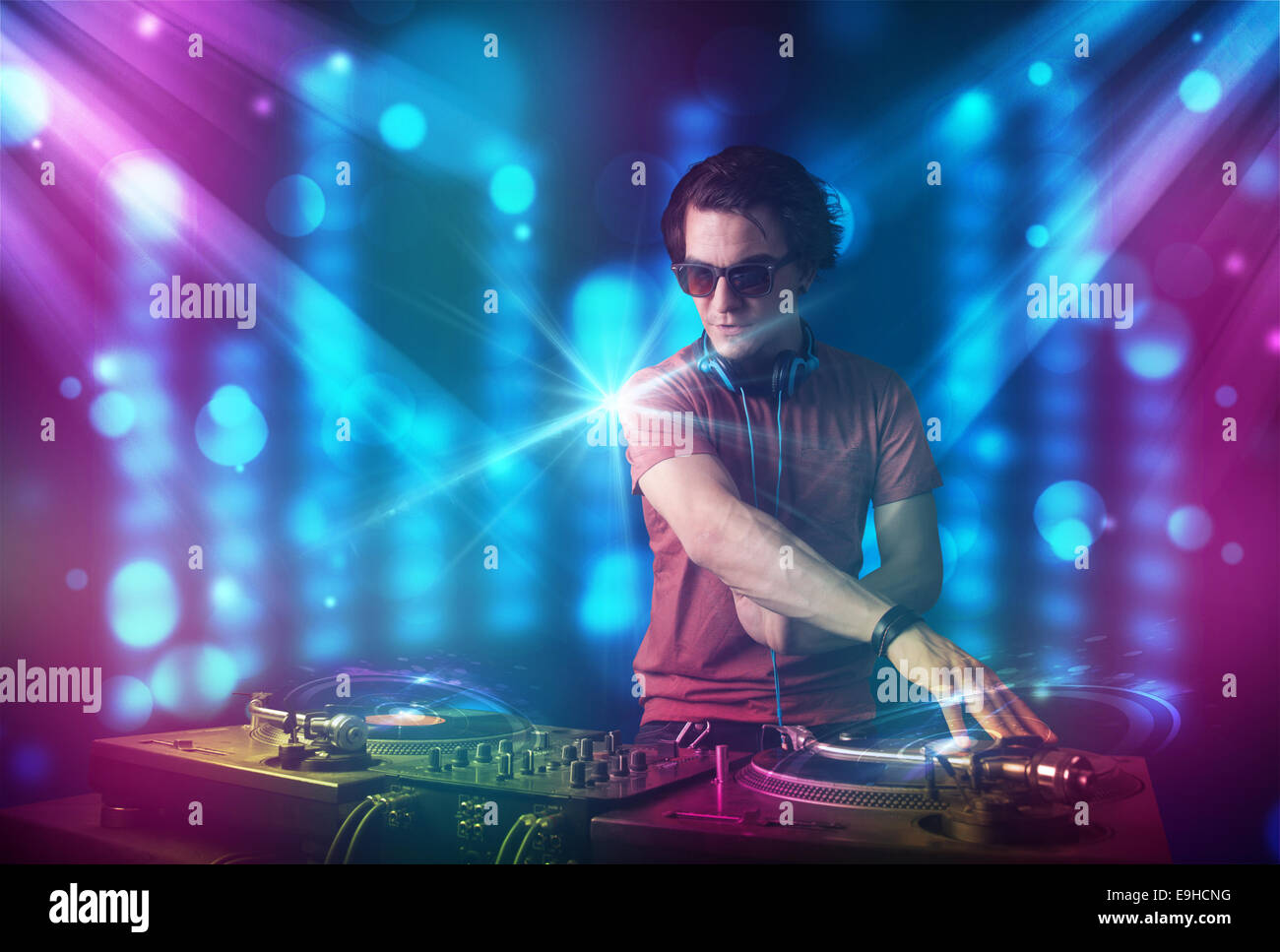 Dj mixing music in a club with blue and purple lights Stock Photo - Alamy