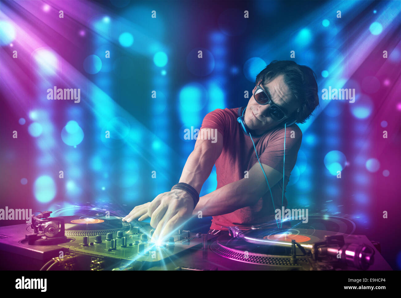 Dj mixing music in a club with blue and purple lights Stock Photo - Alamy