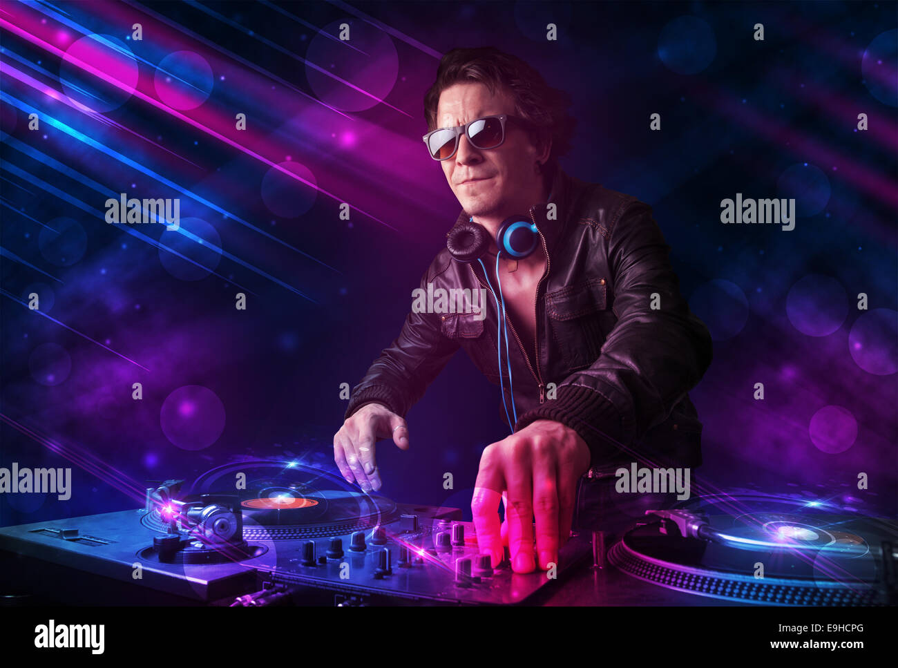 Young DJ playing on turntables with color light effects Stock Photo - Alamy