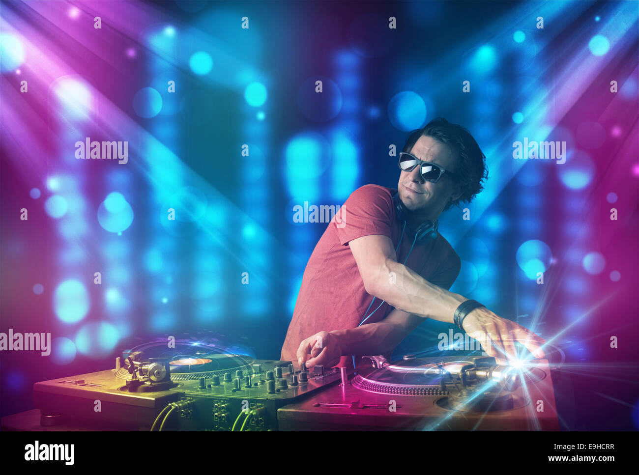 Dj mixing music in a club with blue and purple lights Stock Photo - Alamy