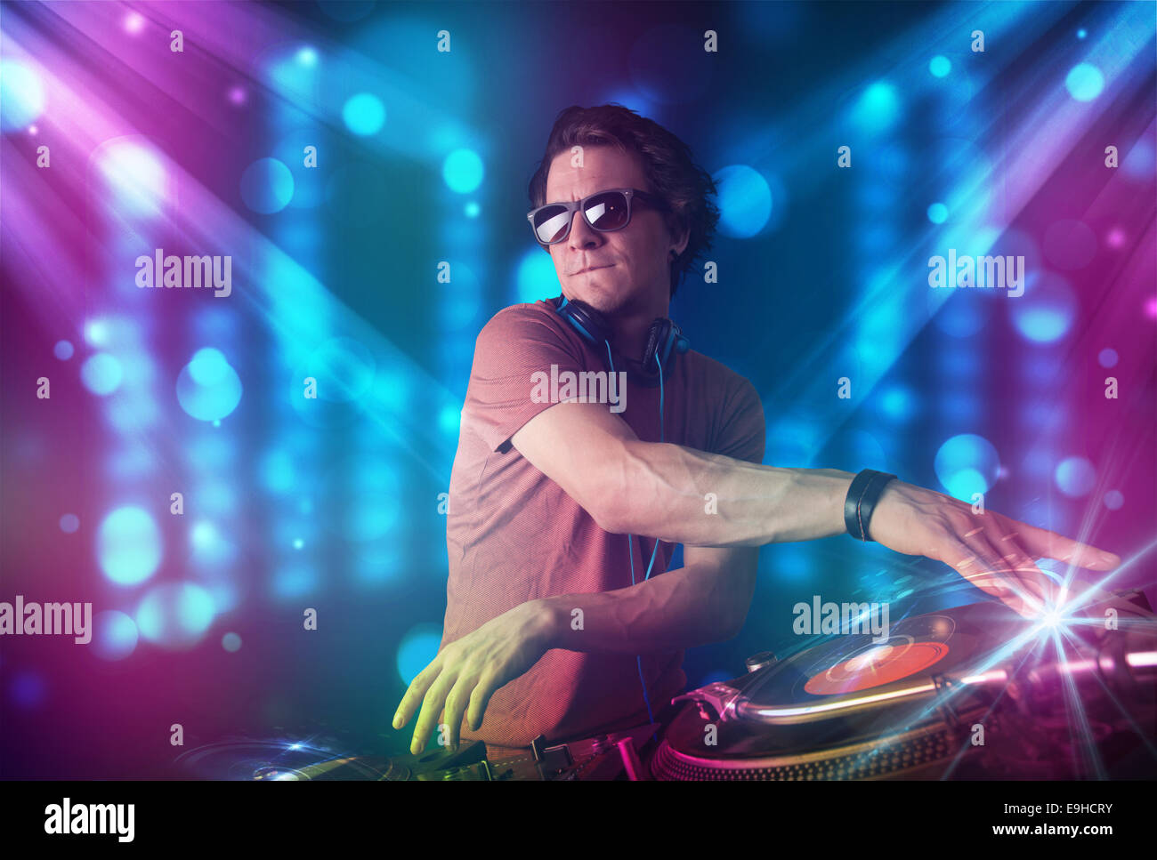 Dj mixing music in a club with blue and purple lights Stock Photo - Alamy