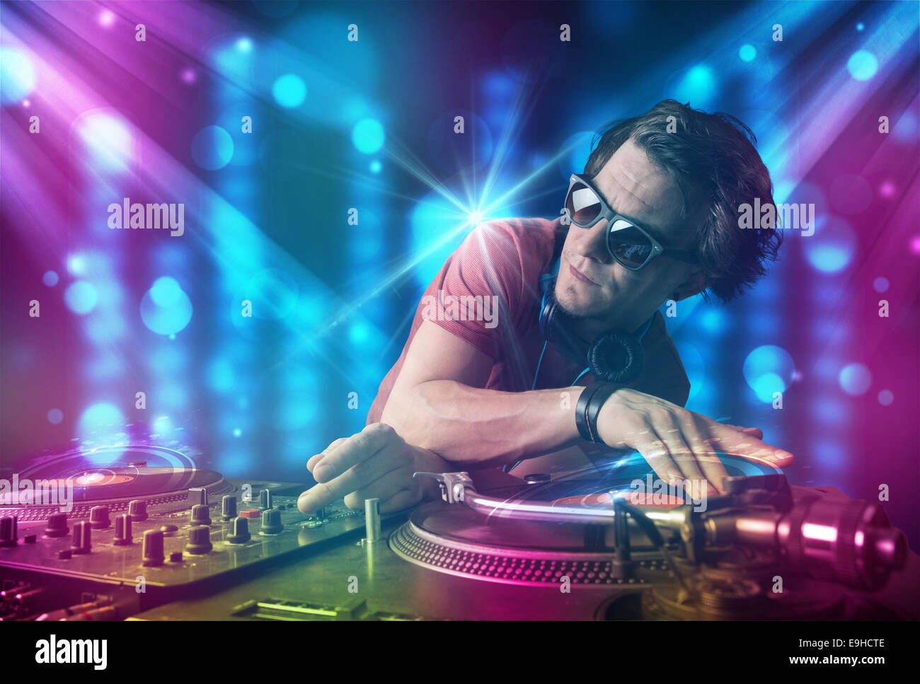 Dj mixing music in a club with blue and purple lights Stock Photo - Alamy