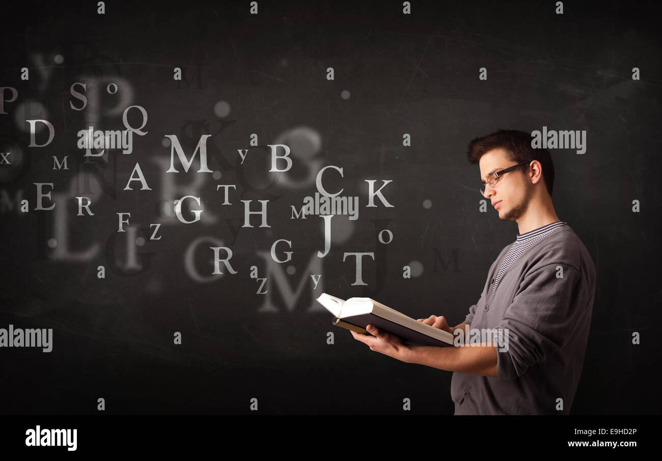 Young man reading a book with alphabet letters Stock Photo - Alamy