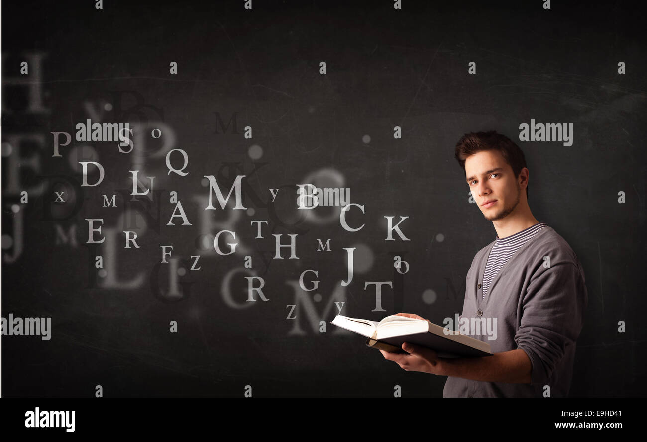 Young man reading a book with alphabet letters Stock Photo - Alamy