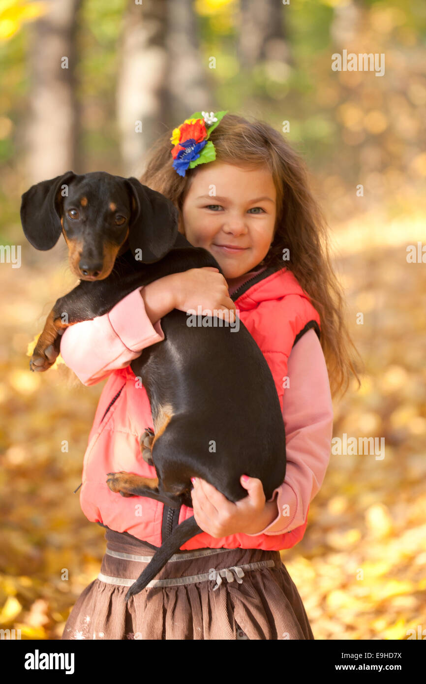 Little kid with a dachshund puppy. Girl and dog cuddling Stock Photo ...