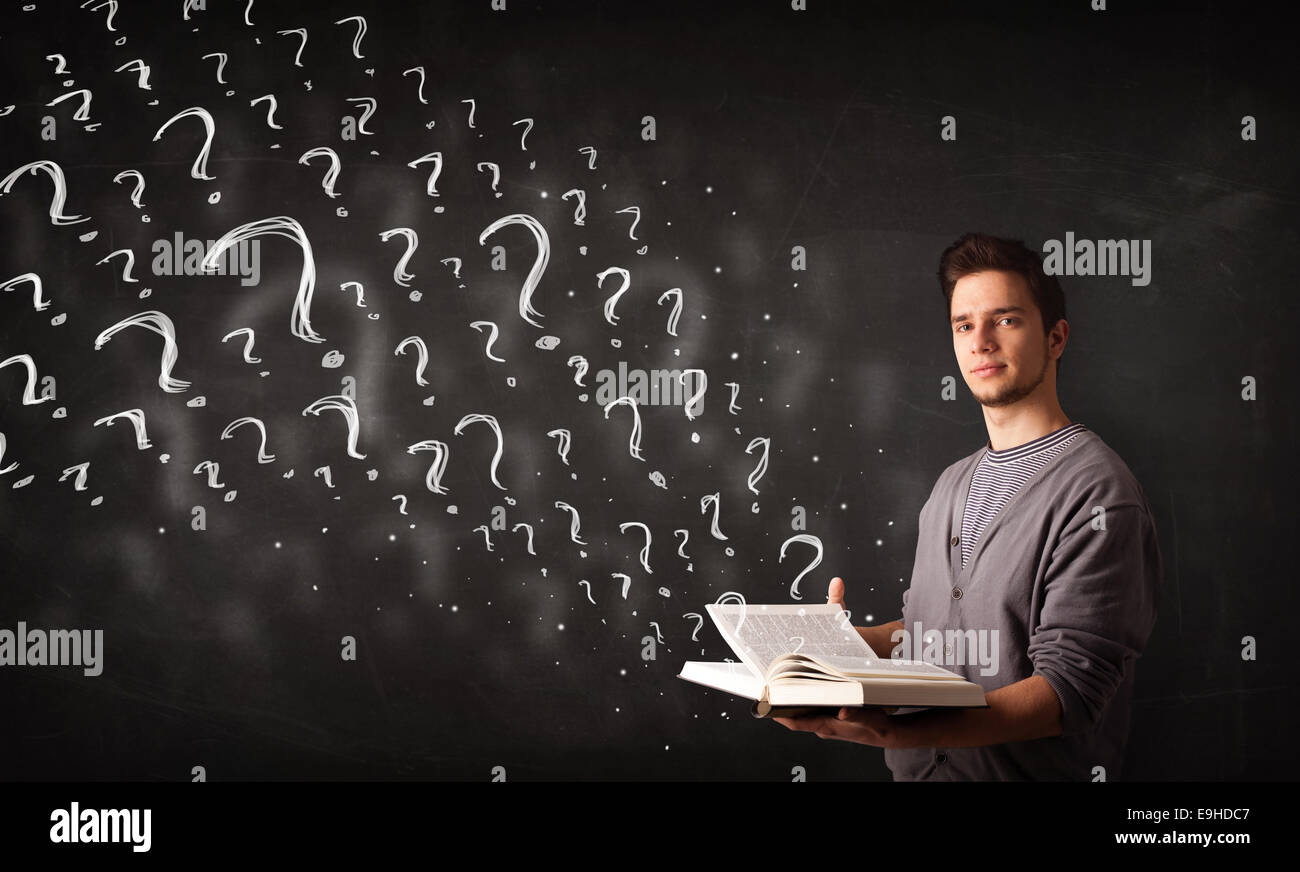 Young man reading a book with question marks coming out from it Stock ...