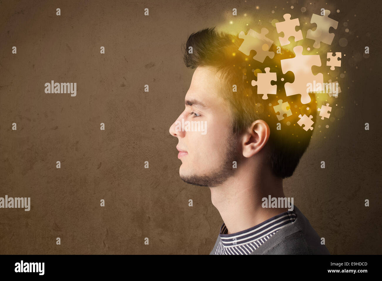 Young person thinking with glowing puzzle mind Stock Photo - Alamy
