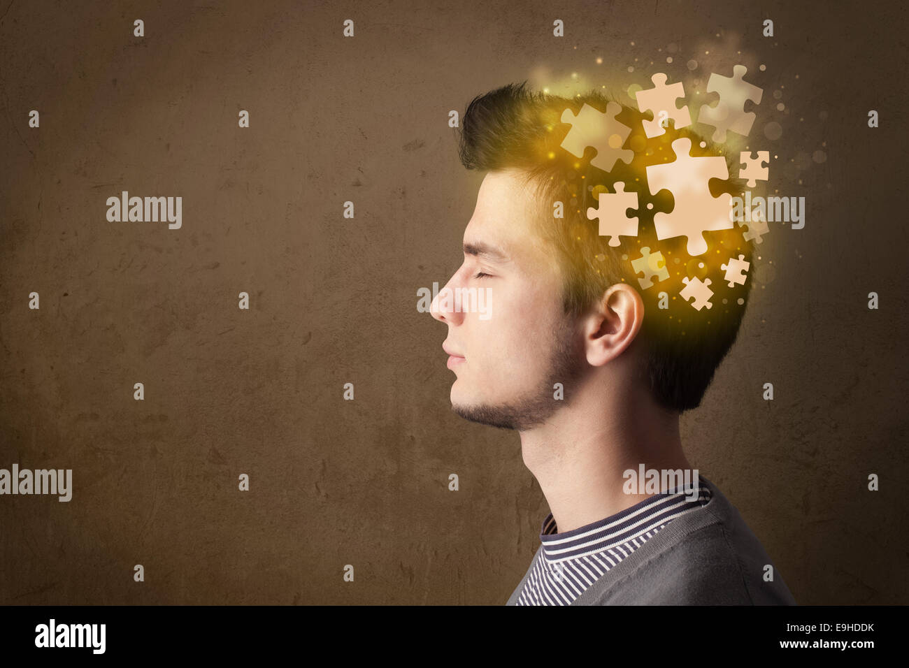 Young person thinking with glowing puzzle mind Stock Photo - Alamy