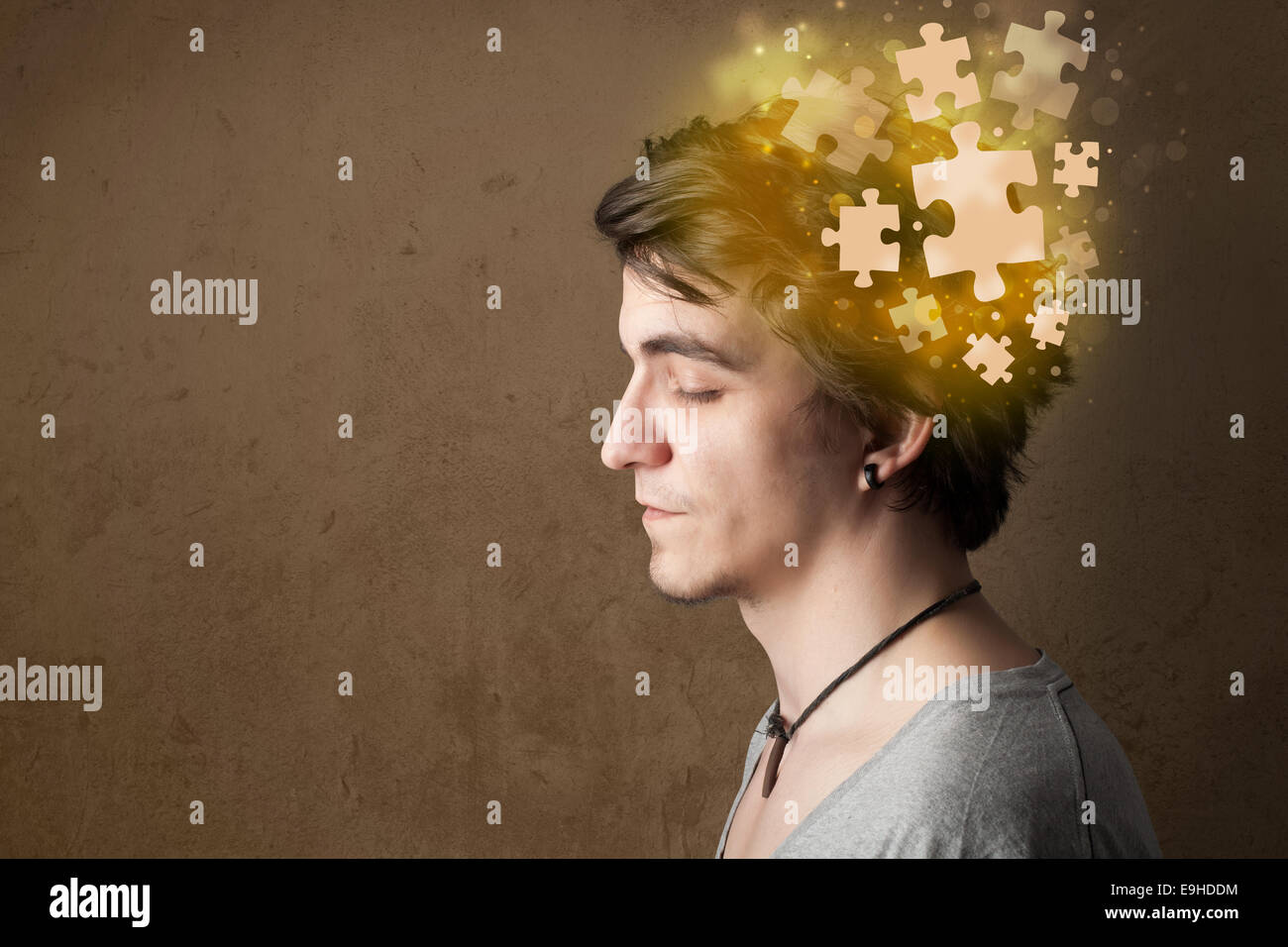 Young person thinking with glowing puzzle mind Stock Photo - Alamy