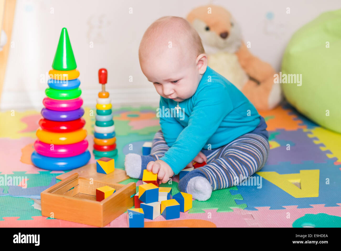 Cute little baby playing with colorful toys at home Stock Photo - Alamy