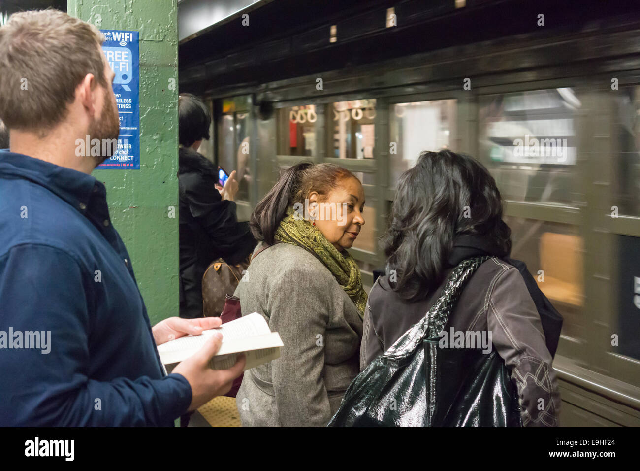 Subway riders watch the arrival of a vintage Lo-V (Low Voltage) MTA ...