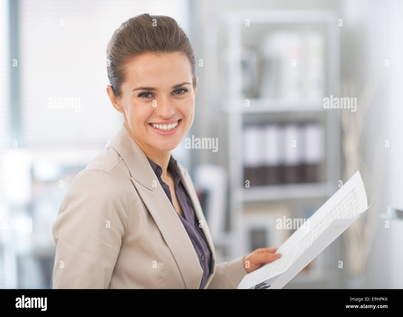 Portrait of happy business woman with documents in office Stock Photo ...