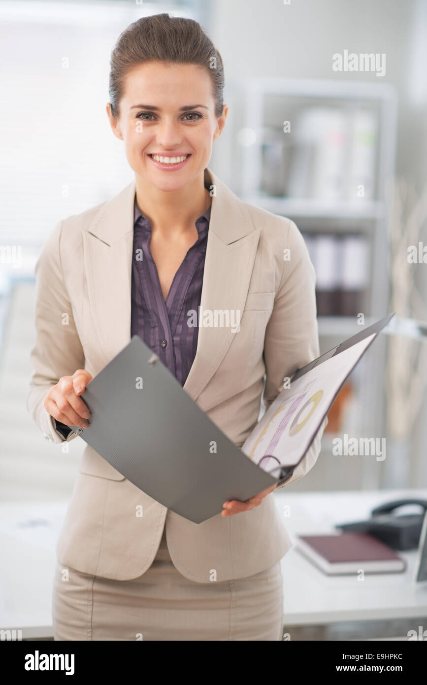 Portrait of happy business woman with documents in office Stock Photo ...