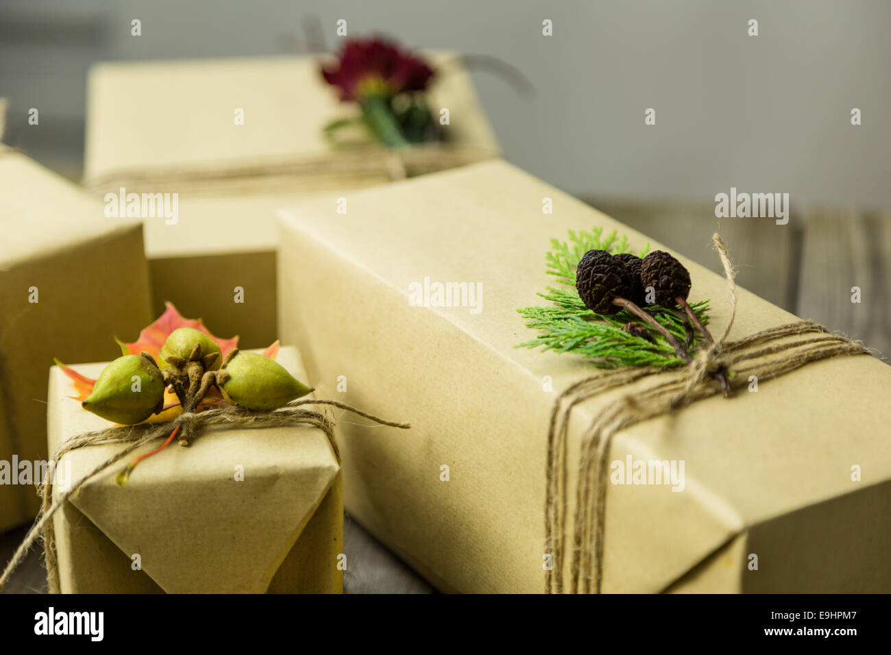 Gifts wrapped in kraft paper, tied with twine and embellished with ...