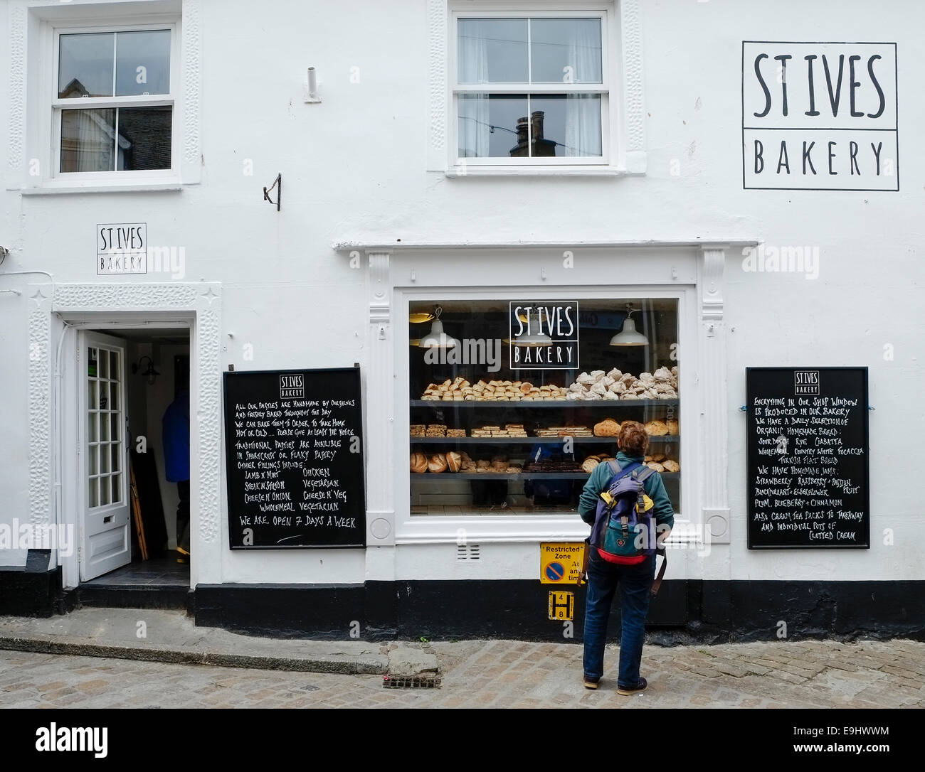 A man looks into the window of St Ives Bakery , Is Ives, Cornwall UK ...
