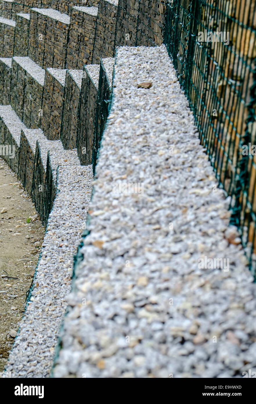 A retaining wall made up of caged stones Stock Photo - Alamy