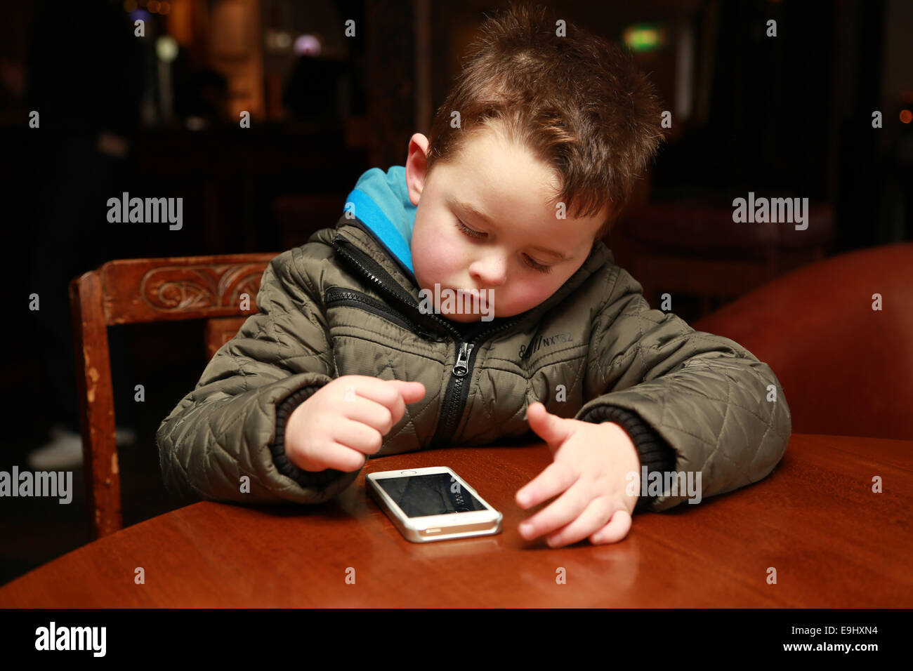 Bored child on mobile phone Stock Photo - Alamy
