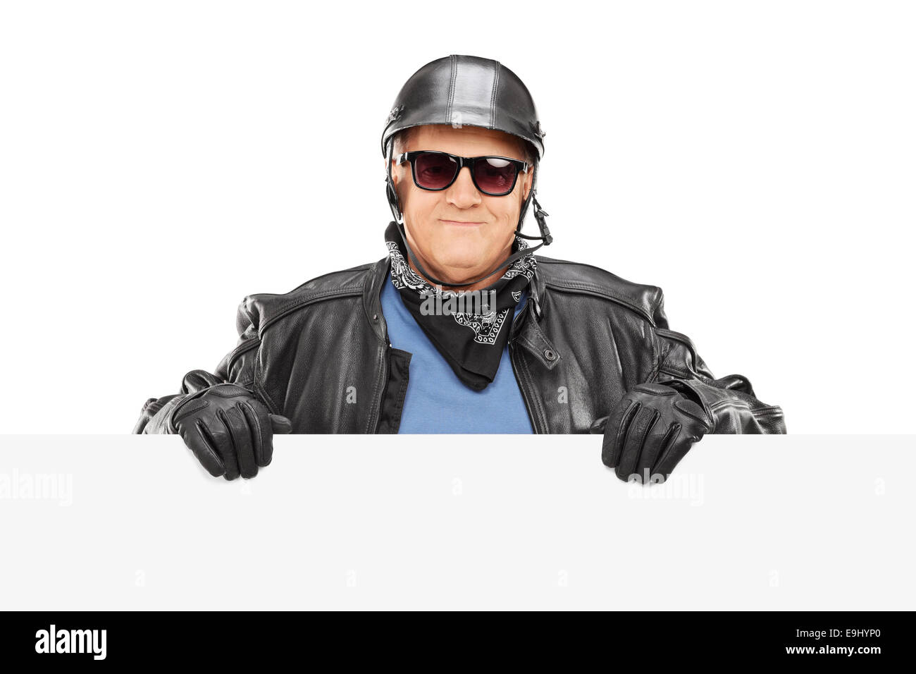 Mature biker standing behind a blank billboard isolated on white ...