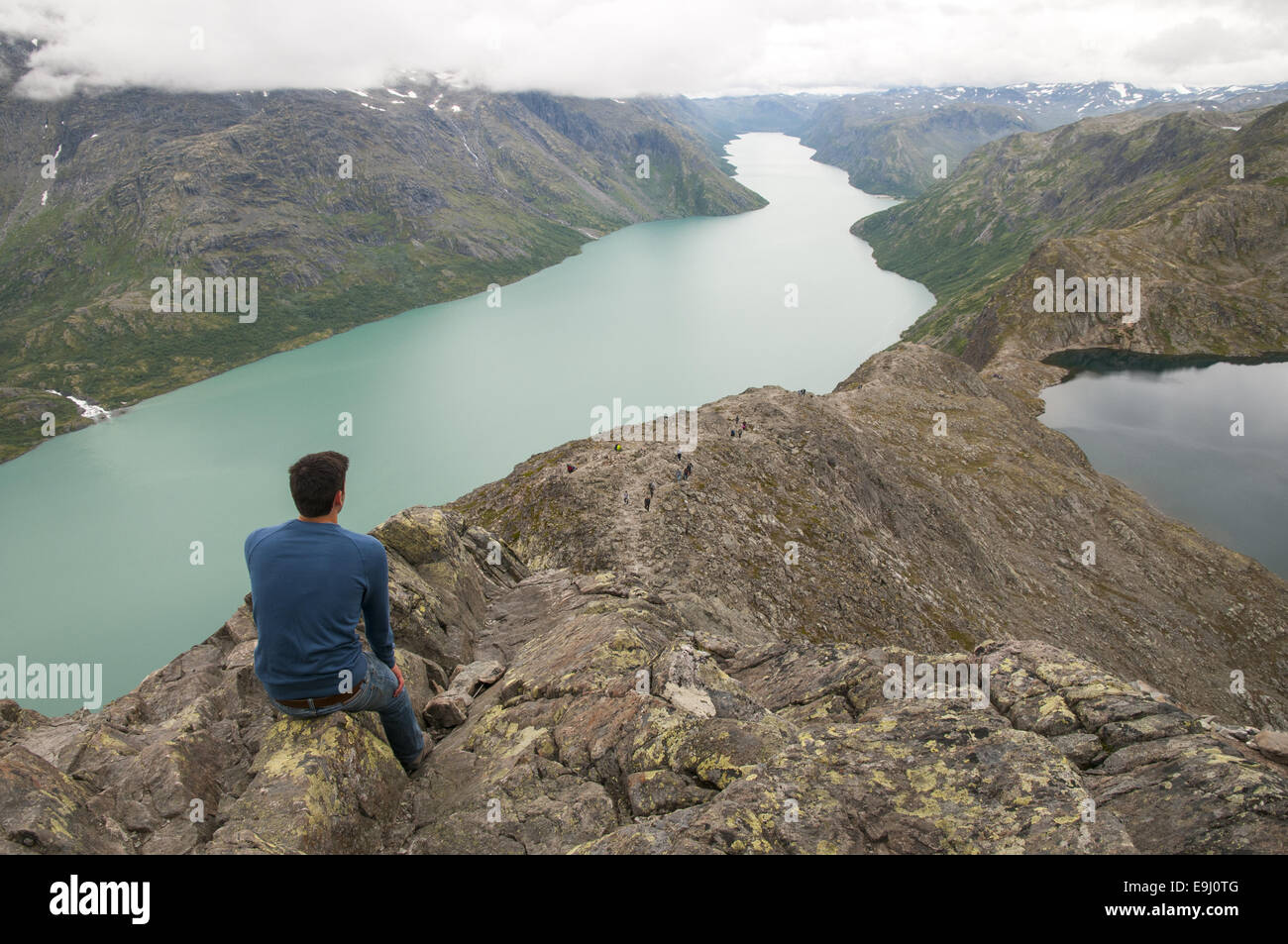 Hikers ascending the western ridge of Besseggen mountain with view over ...