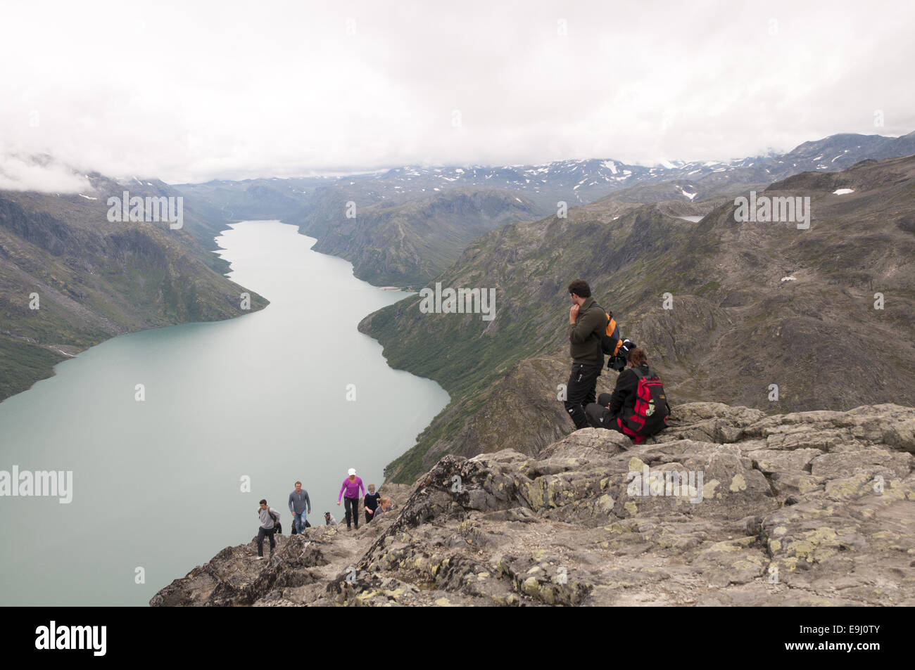Hikers ascending the western ridge of Besseggen mountain with view over ...