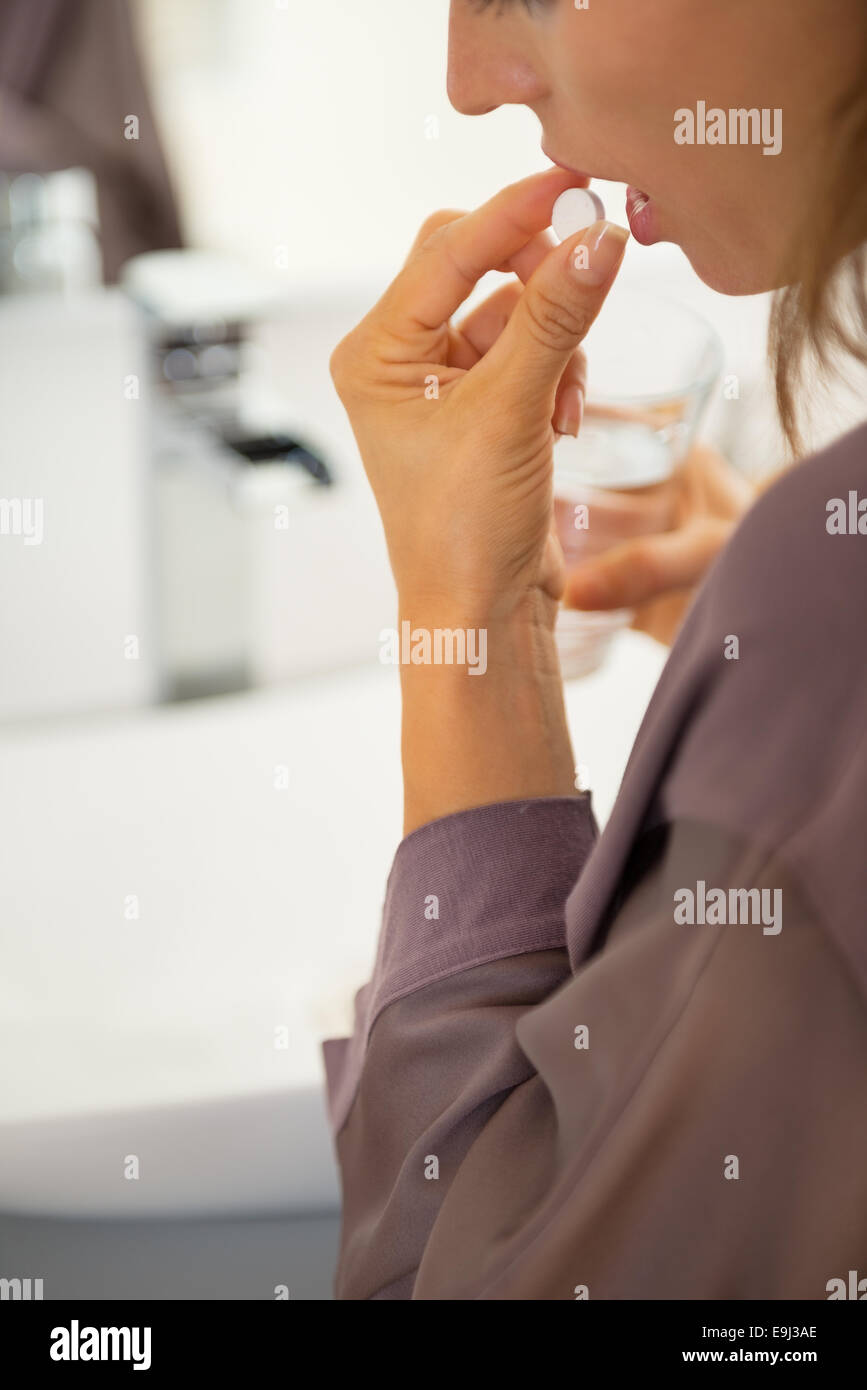 Closeup on young woman eating pill Stock Photo - Alamy