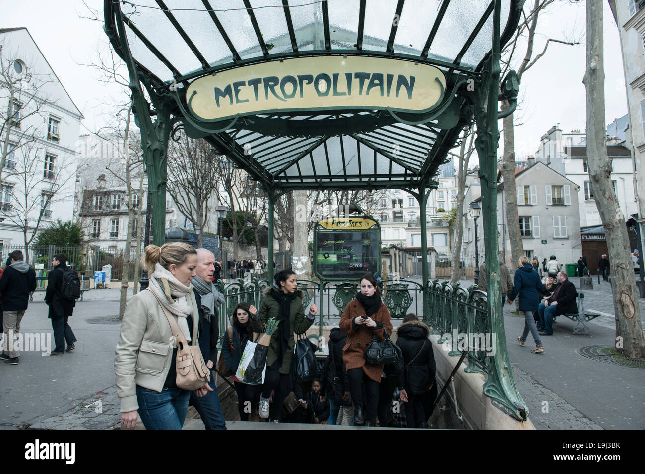 tourists and commuters exit a paris metro train station in winter with ...