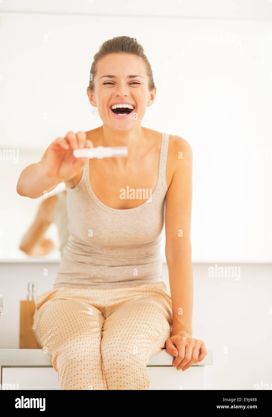 Happy young woman showing pregnancy test Stock Photo - Alamy