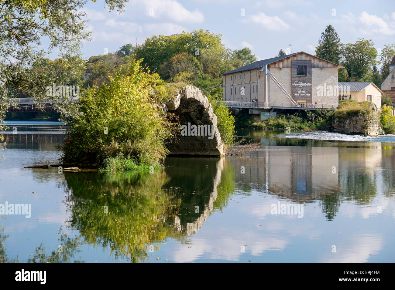 Remains of old Pont Roman bridge arch reflected in calm waters of Le ...