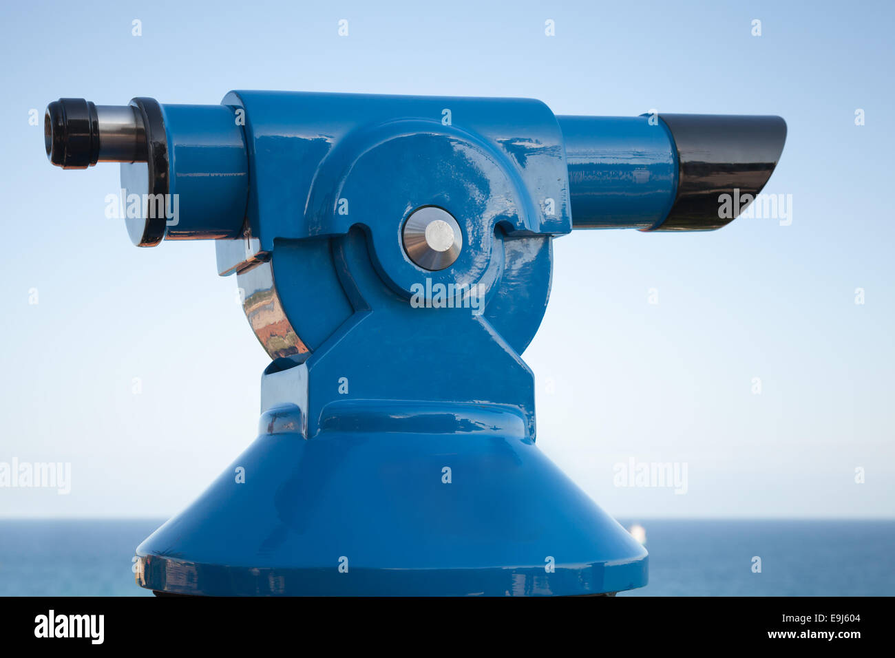 Blue paid tourist telescope on the sea coast over blue sky background ...