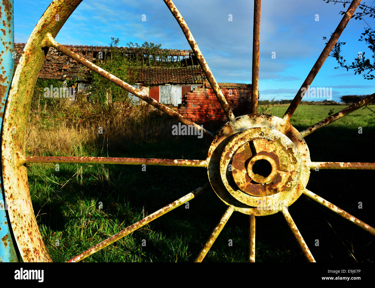 An abandoned farm building with gate made from cart wheels. October ...