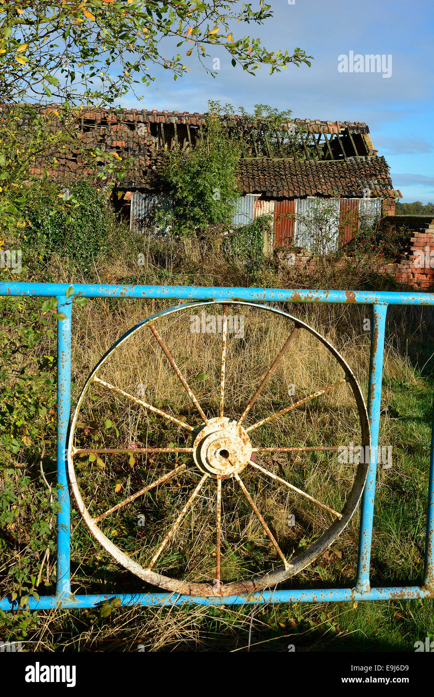 An abandoned farm building with gate made from cart wheels. October ...