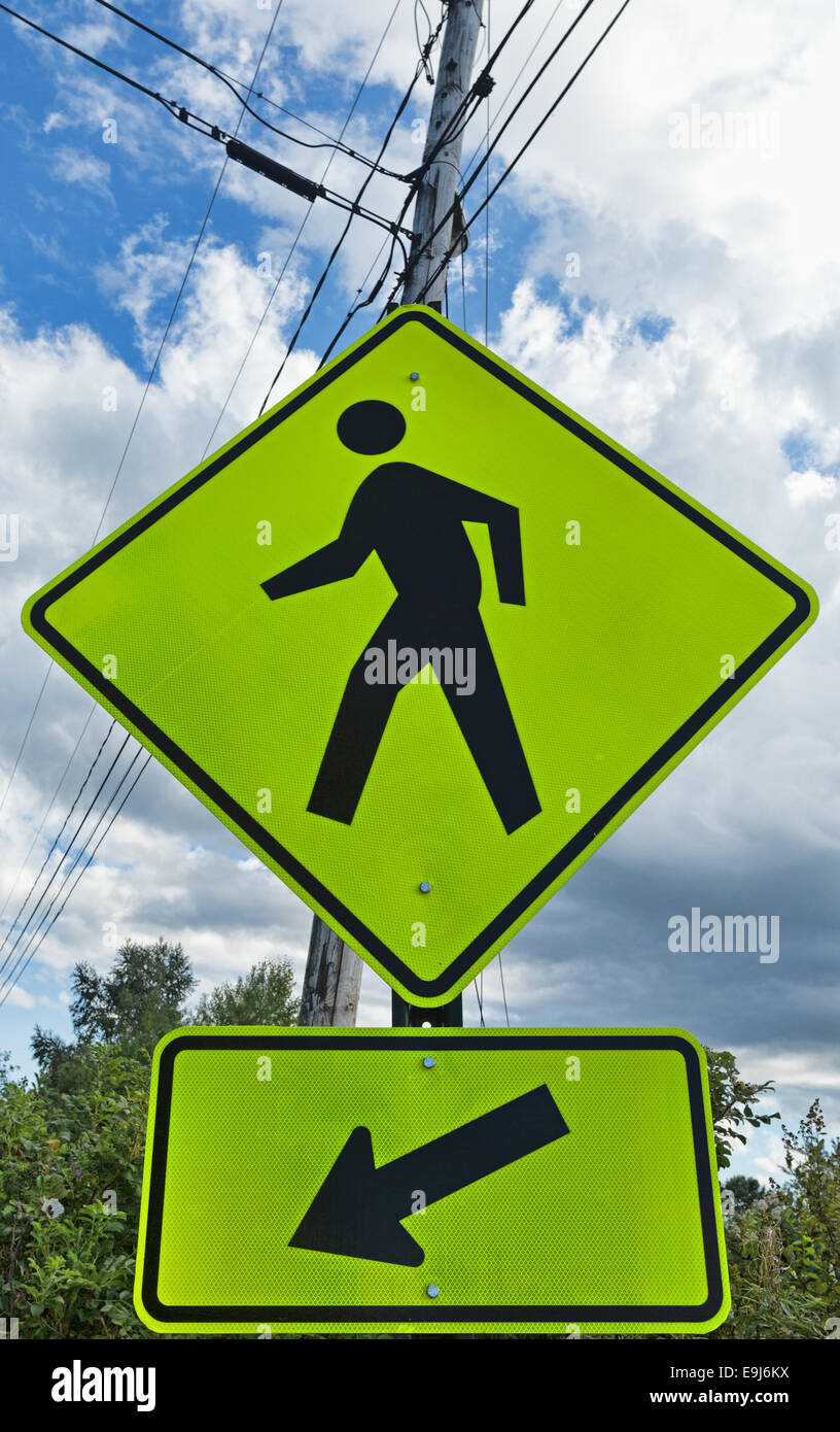 An urban pedestrian crossing sign with above power lines and cloudy ...