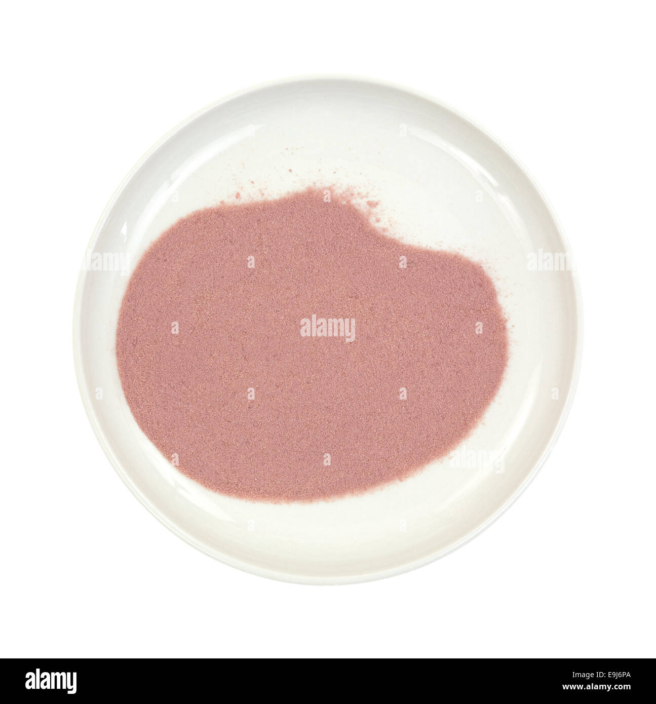 Top view of raspberry gelatin granules in a small dish on a white ...