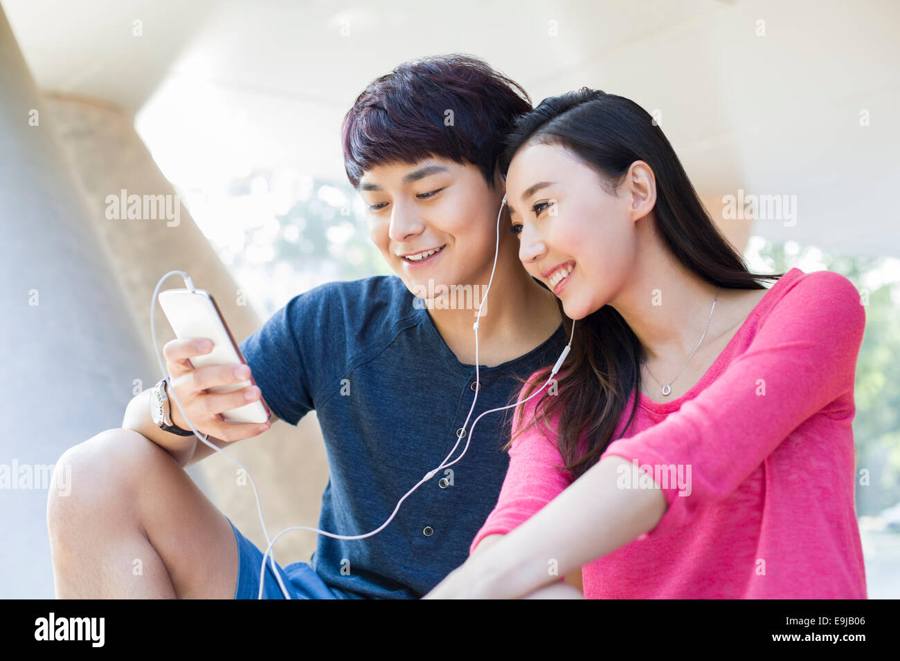 Young couple listening to earphones Stock Photo - Alamy