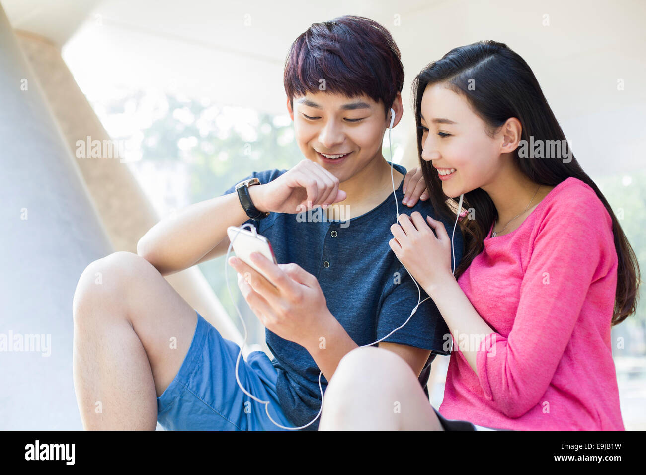 Young couple listening to earphones Stock Photo - Alamy