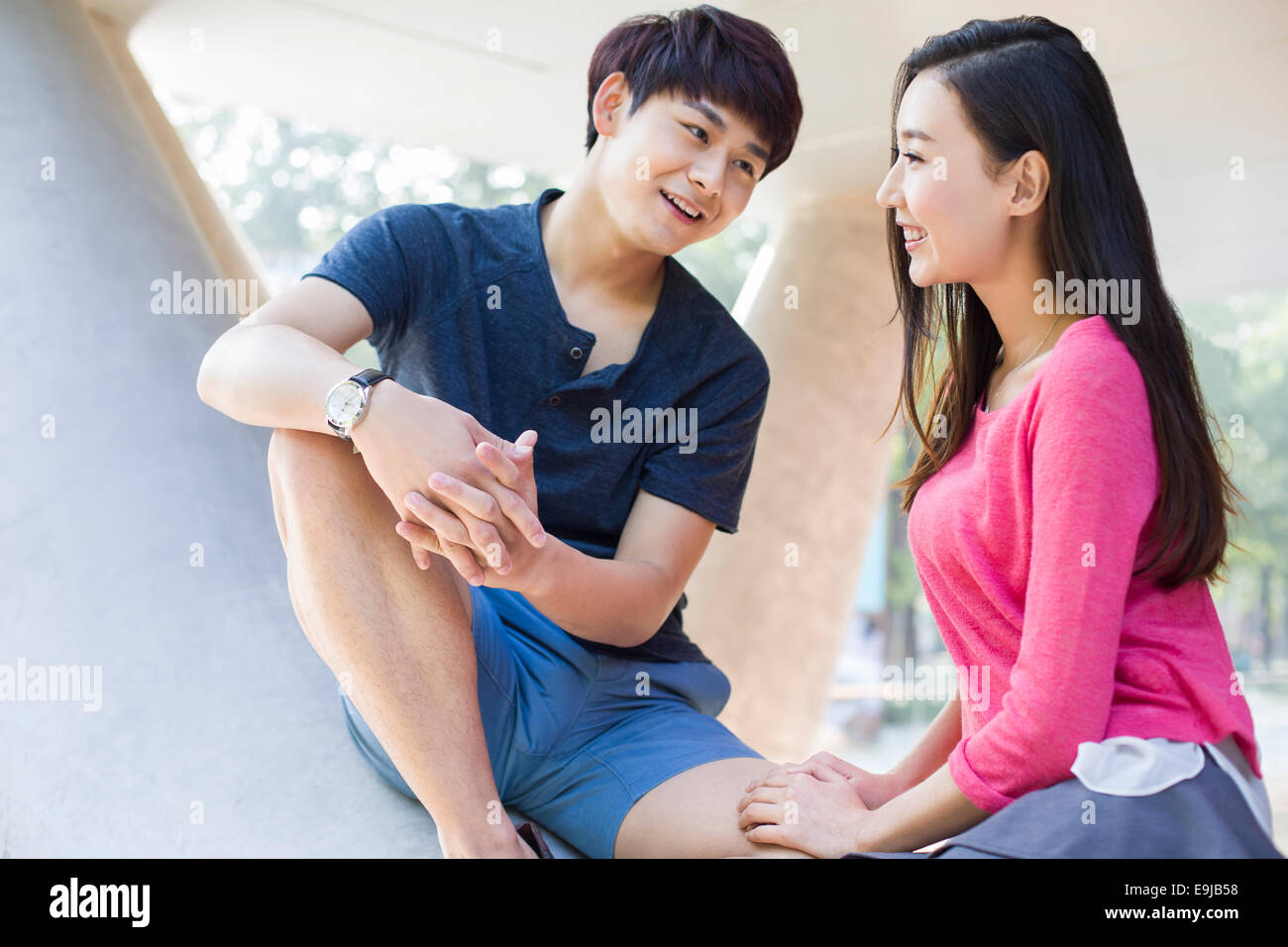 Happy young couple talking Stock Photo - Alamy
